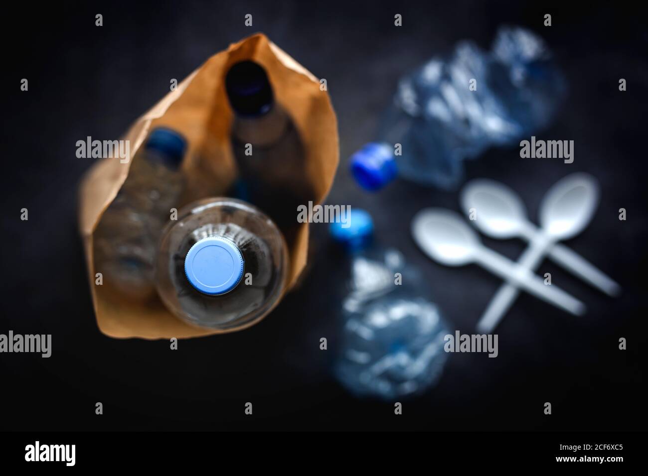 from above dirty paper sack with discarded plastic bottles placed on ...