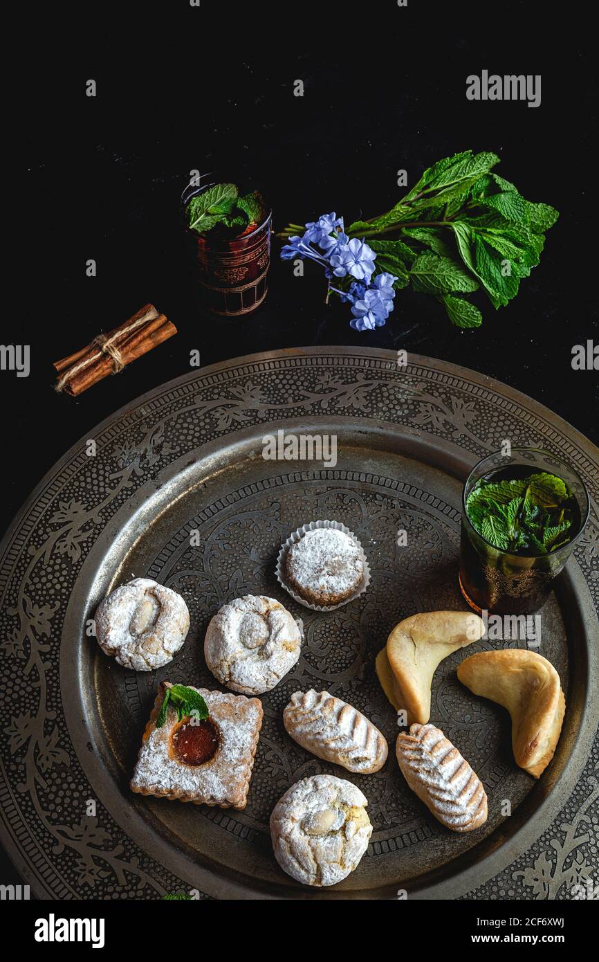 Traditional tea with mint and assorted homedade Arab sweets on dark ...