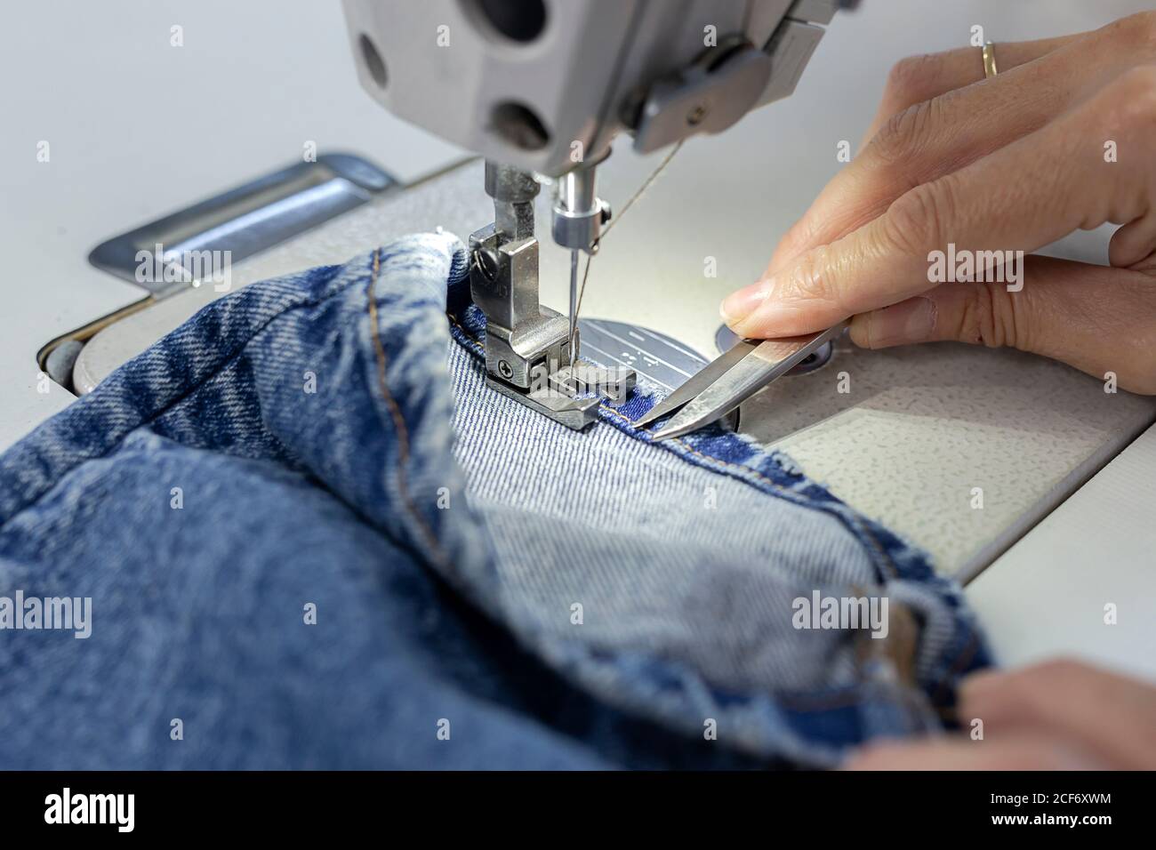 Working Woman hands in textile factory sewing on industrial sewing ...