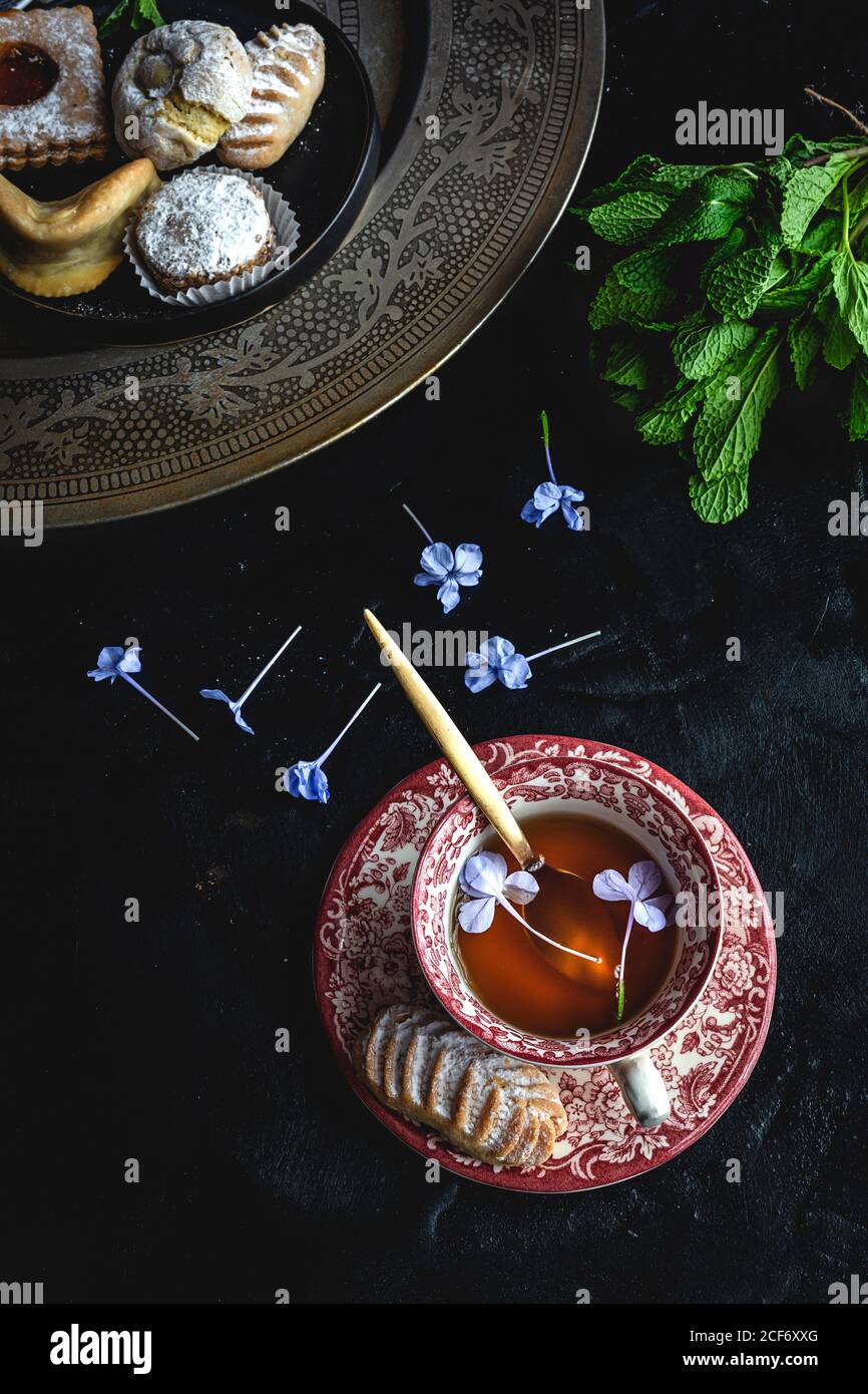 Traditional tea with mint and assorted homedade Arab sweets on dark ...
