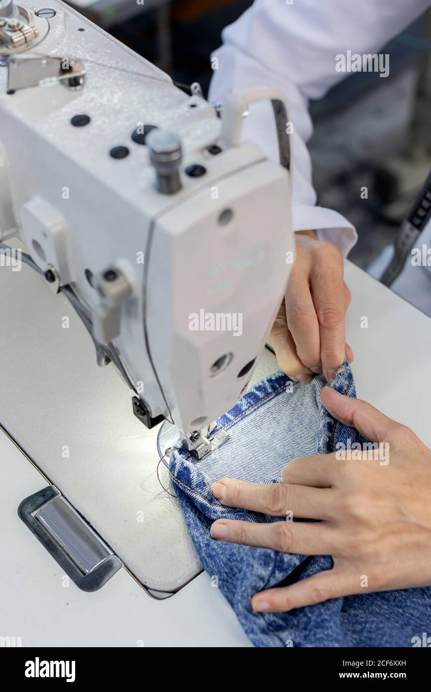 Working Woman hands in textile factory sewing on industrial sewing ...