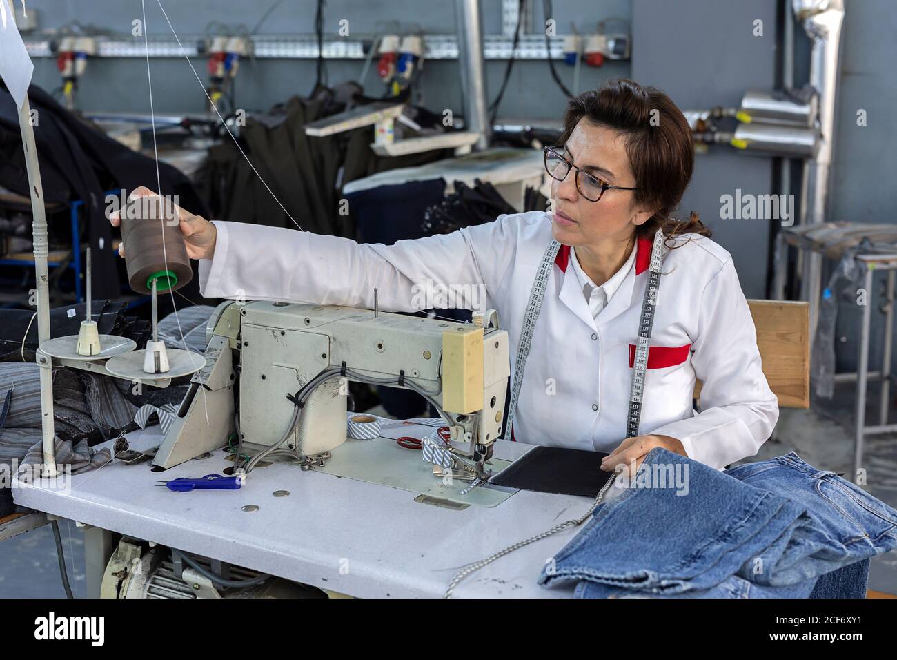 Working Woman hands in textile factory sewing on industrial sewing ...