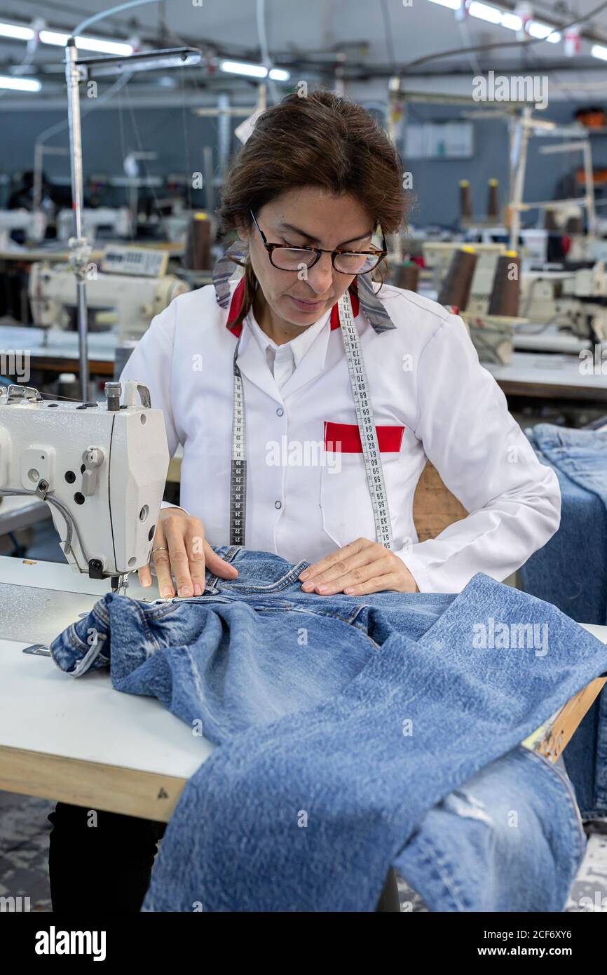 Working Woman hands in textile factory sewing on industrial sewing ...