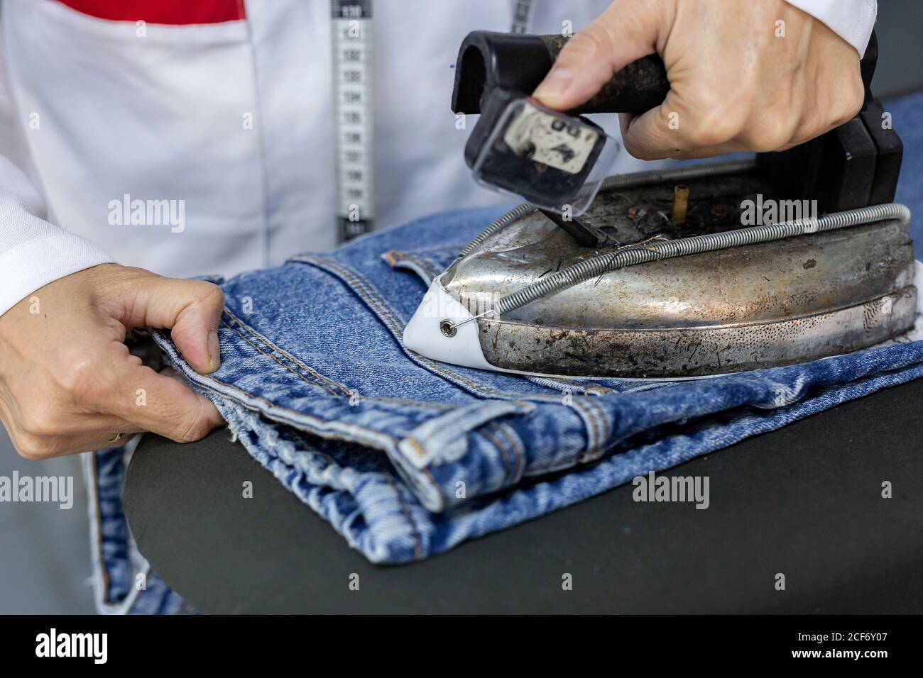 Working Woman hands in textile factory ironing on industrial sewing ...