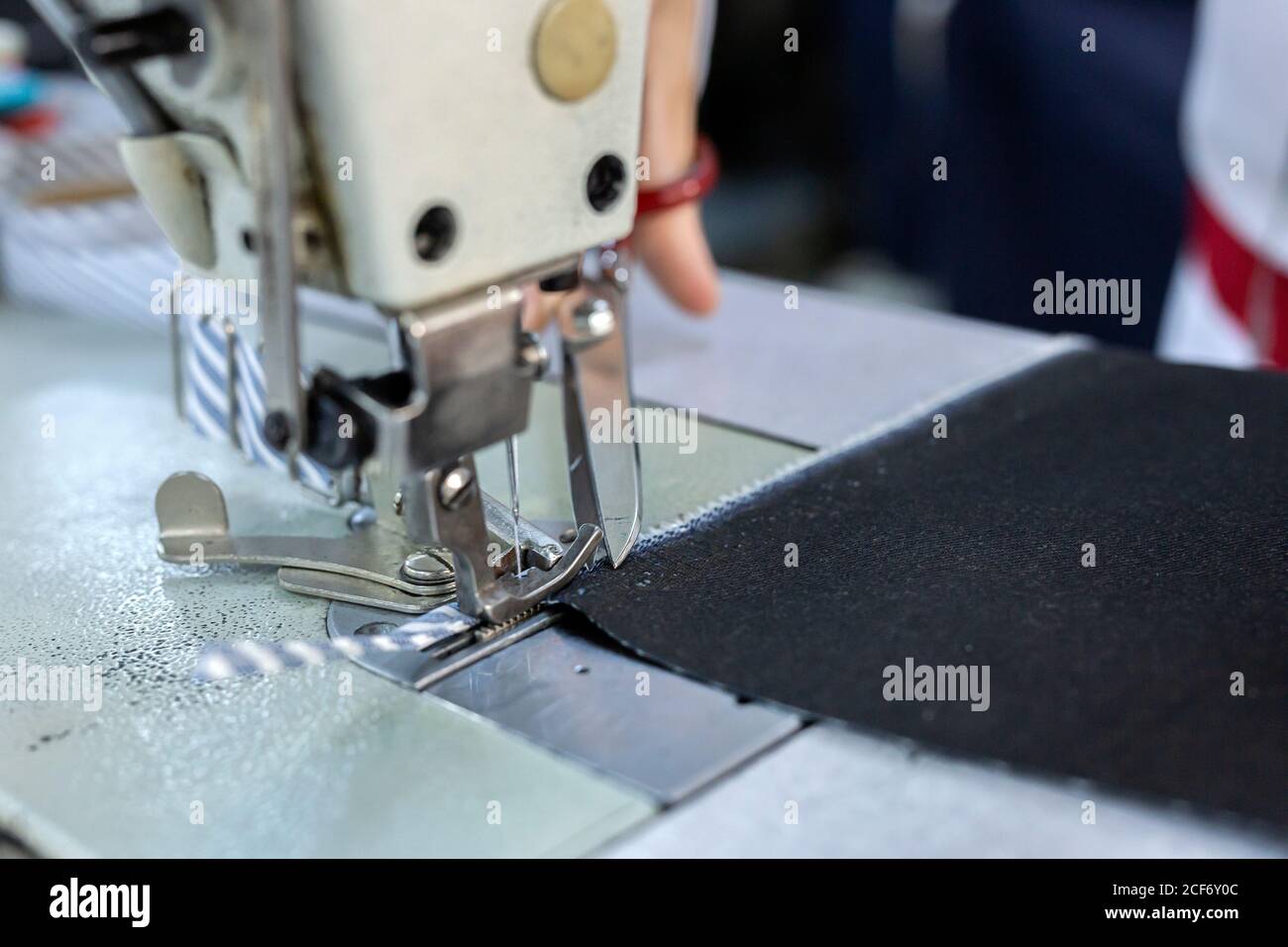 Working Woman hands in textile factory sewing on industrial sewing ...