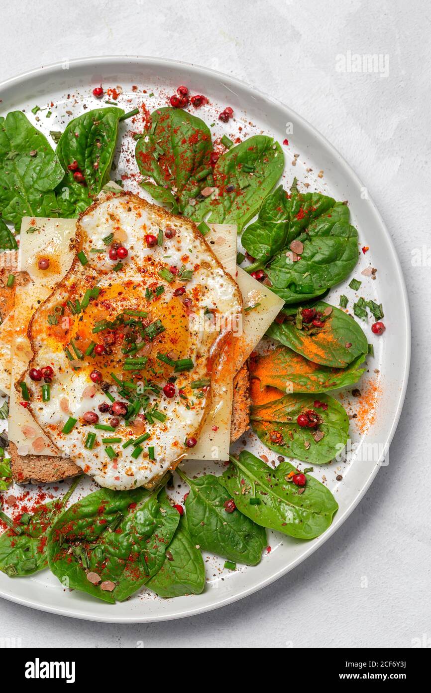 Homemade toasted bread from above with fried egg, spinach and aromatic ...