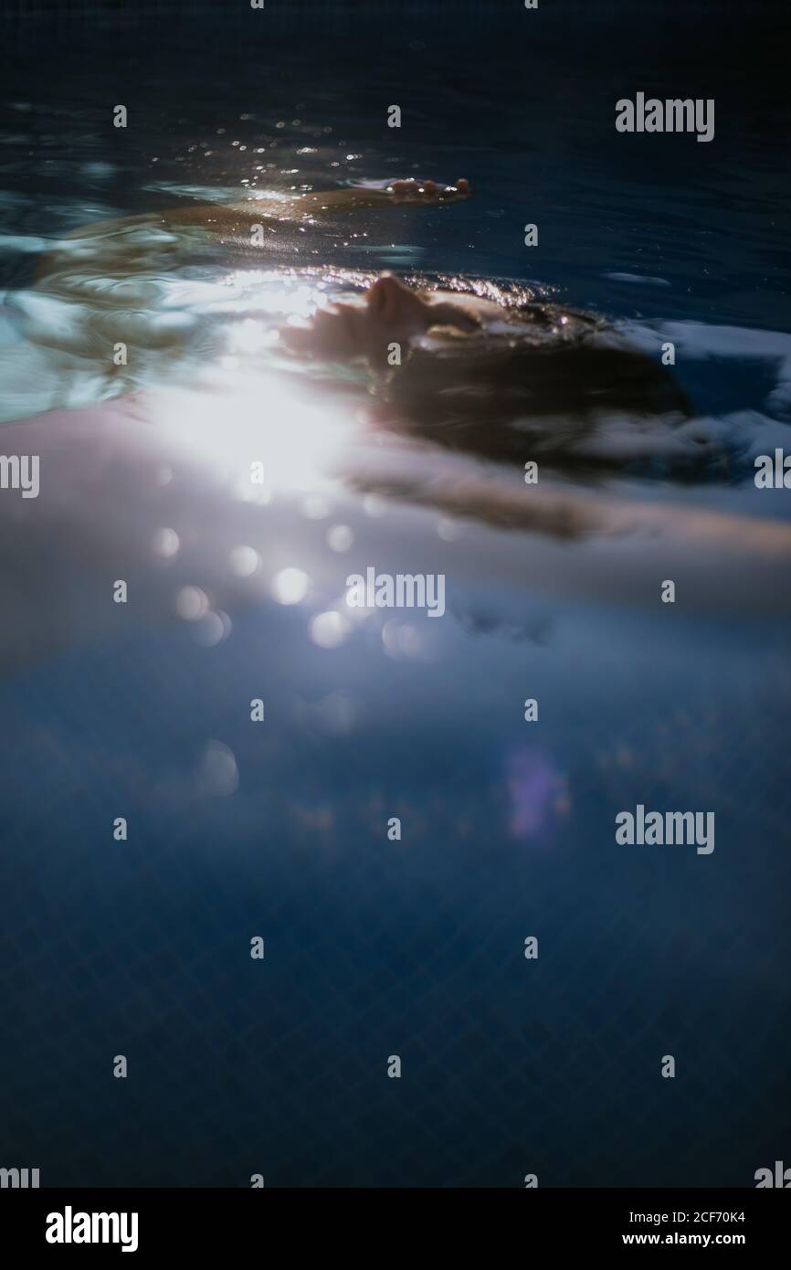 Side view of face above water surface of resting tranquil Woman with ...