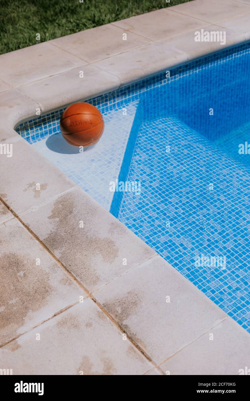 From above of basketball ball in corner on swimming pool in terrace of ...