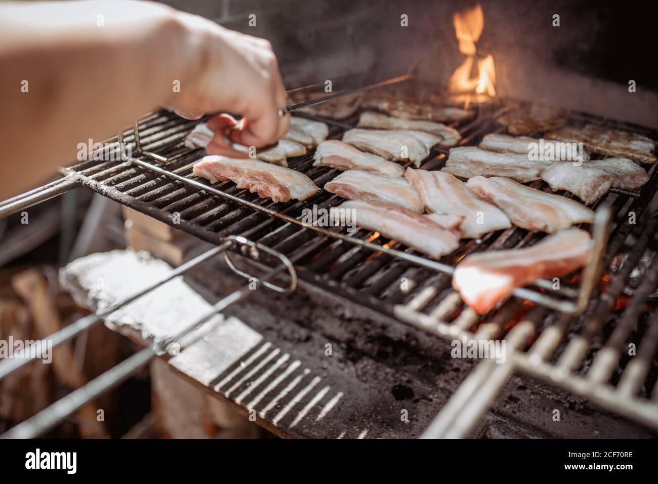 crop person cooking bacon in barbecue Stock Photo - Alamy