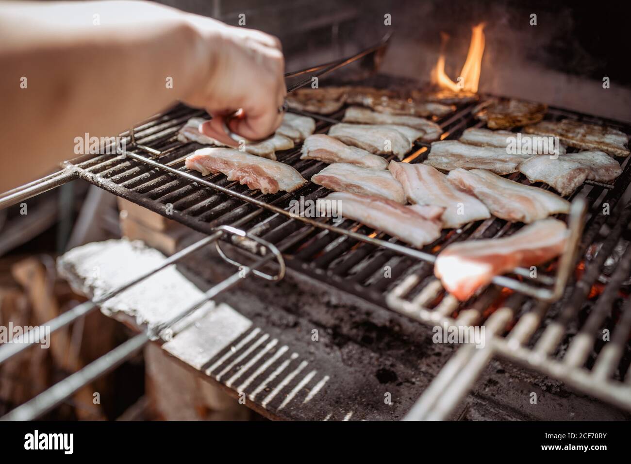crop person cooking bacon in barbecue Stock Photo - Alamy