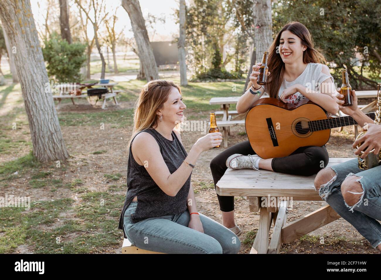 Young musicians drinking beer in park Stock Photo - Alamy