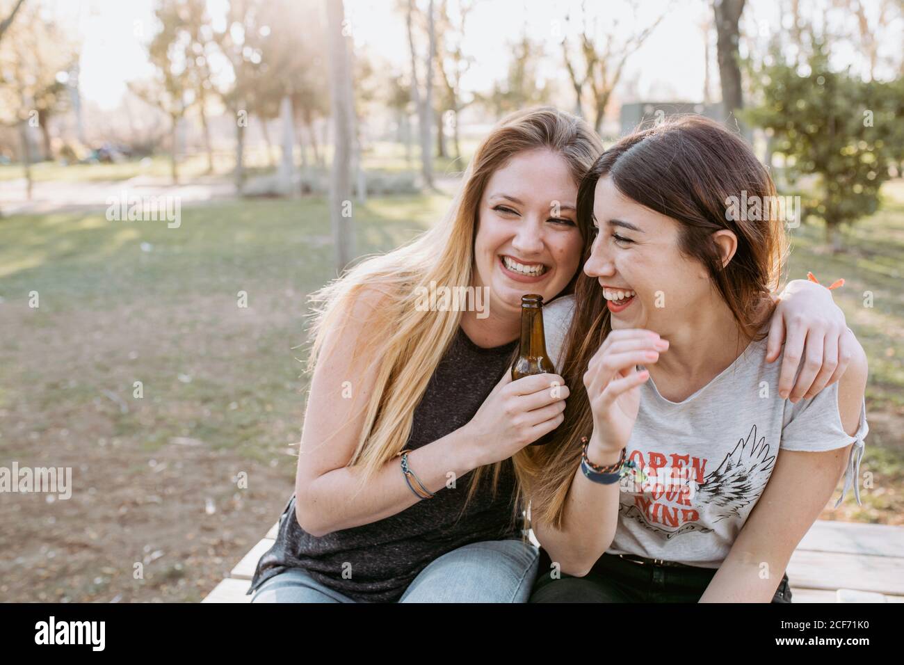 girl friends hugging and laughing in park Stock Photo - Alamy