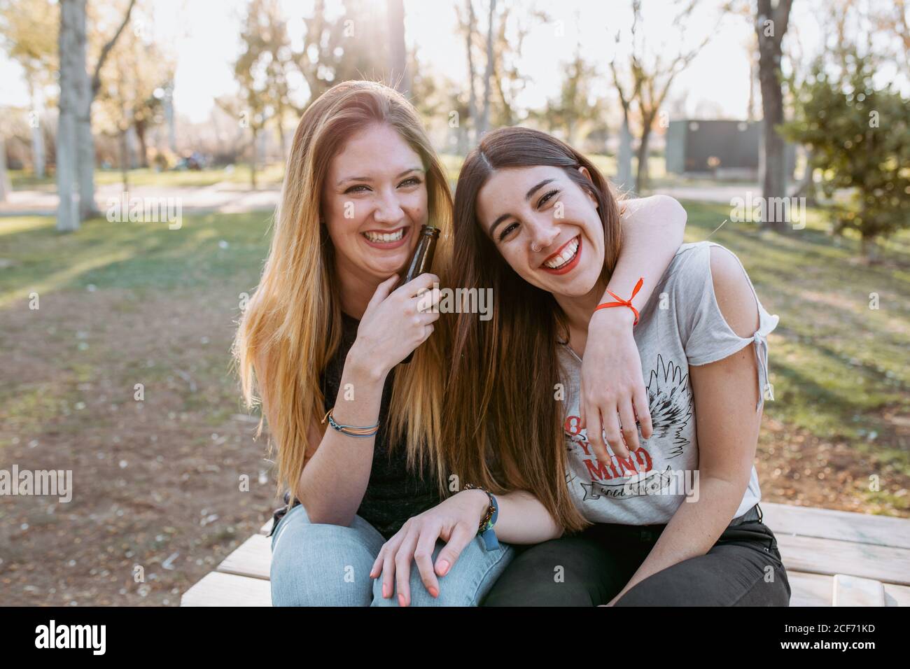 girl friends hugging and laughing in park Stock Photo - Alamy