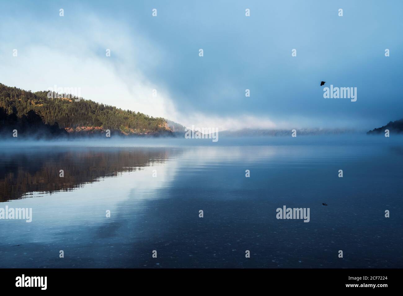 Flawless serene seascape of mountains and lake reflecting clouds and ...