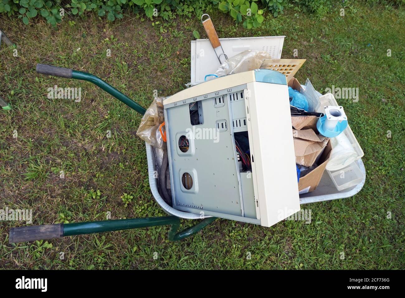 Old rubbish and computer are taken out on a wheelbarrow. Garbage ...