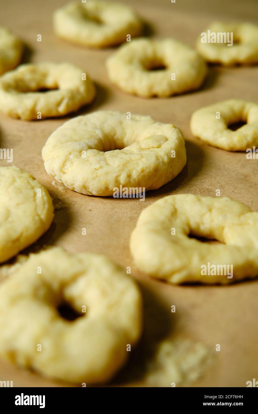 From above rings from soft dough while preparing doughnuts over table ...