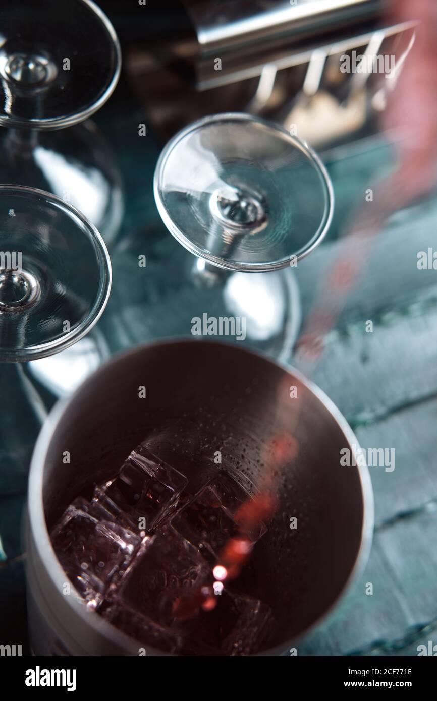 From above process of pouring red alcohol drink from bottle into shaker ...