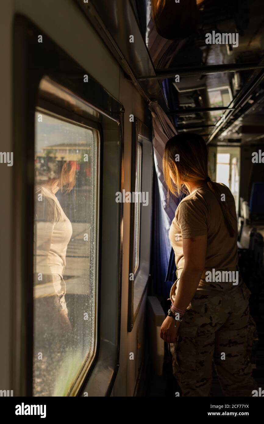 Female soldier looking out window while travelling through countryside ...