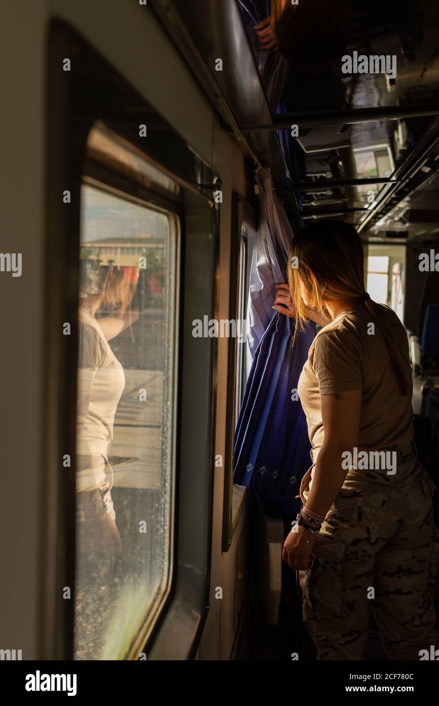 Female soldier looking out window while travelling through countryside ...