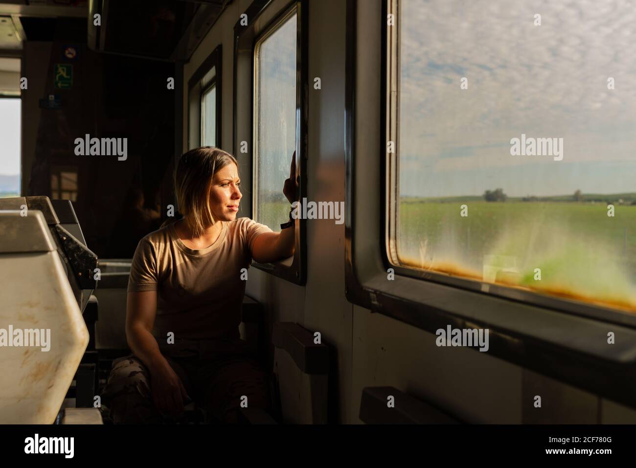 Female soldier looking out window while travelling through countryside ...