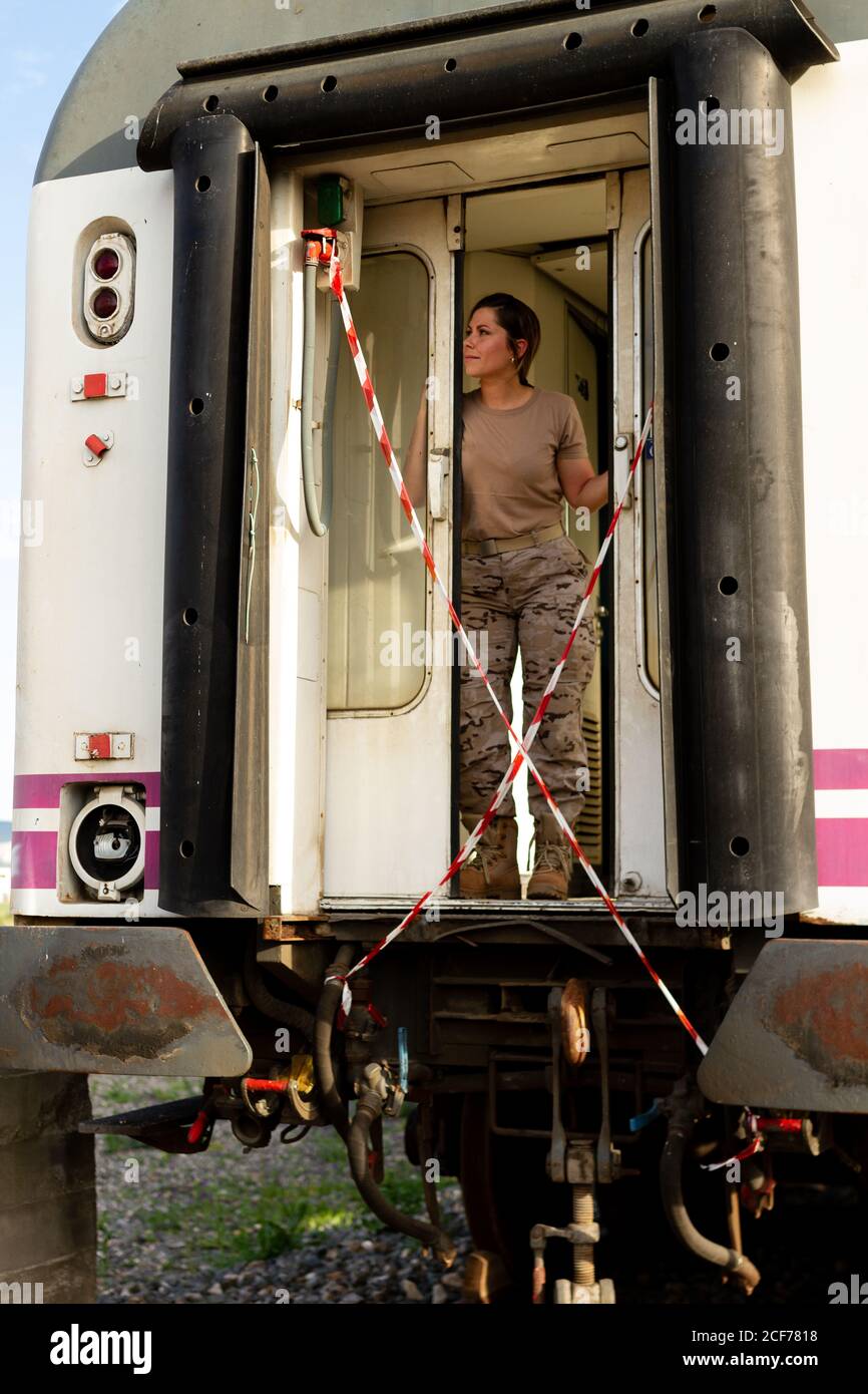Strong female soldier looking away and thinking while standing in ...