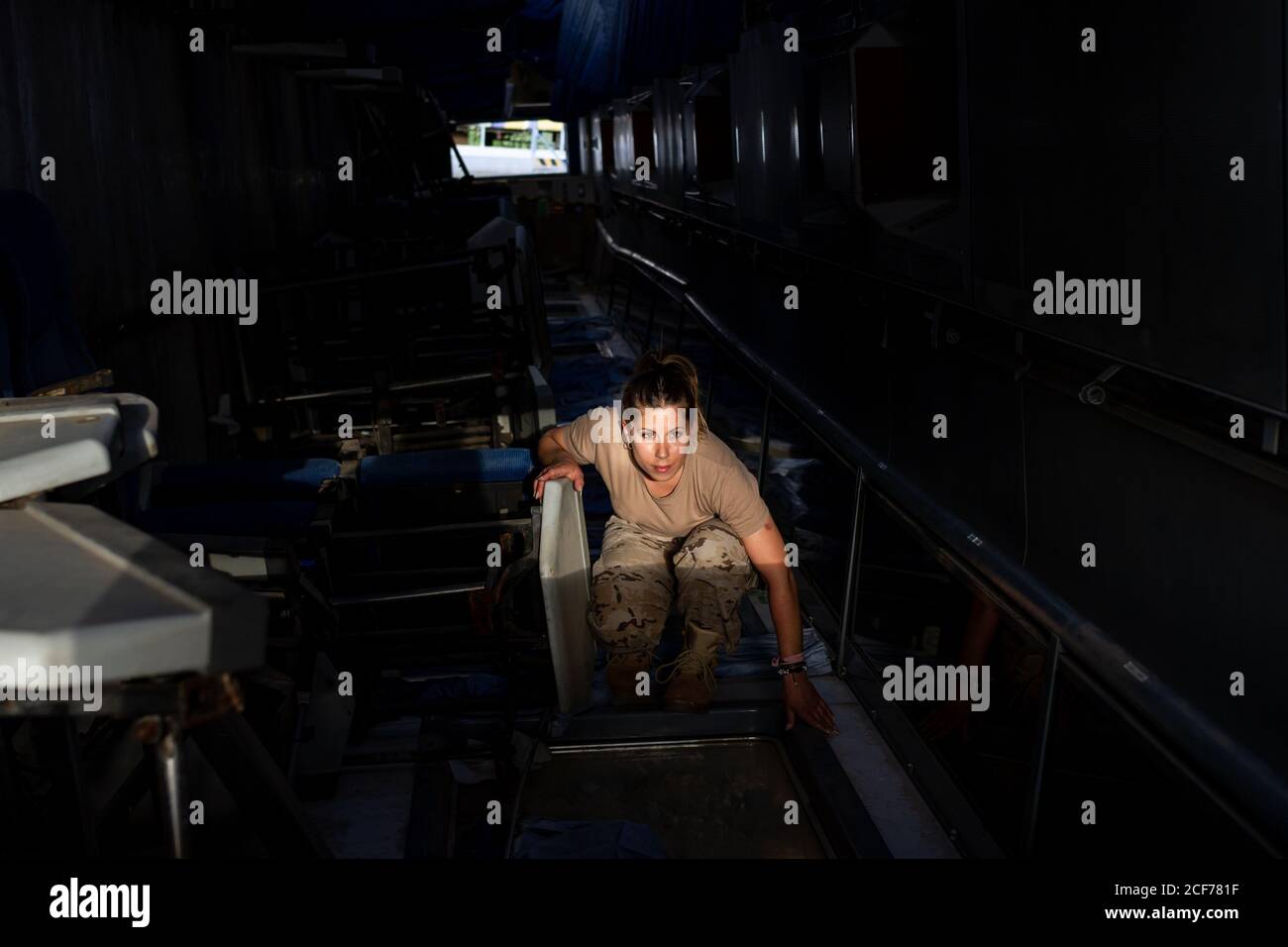 Side view of strong female soldier pointing up while looking at sky ...