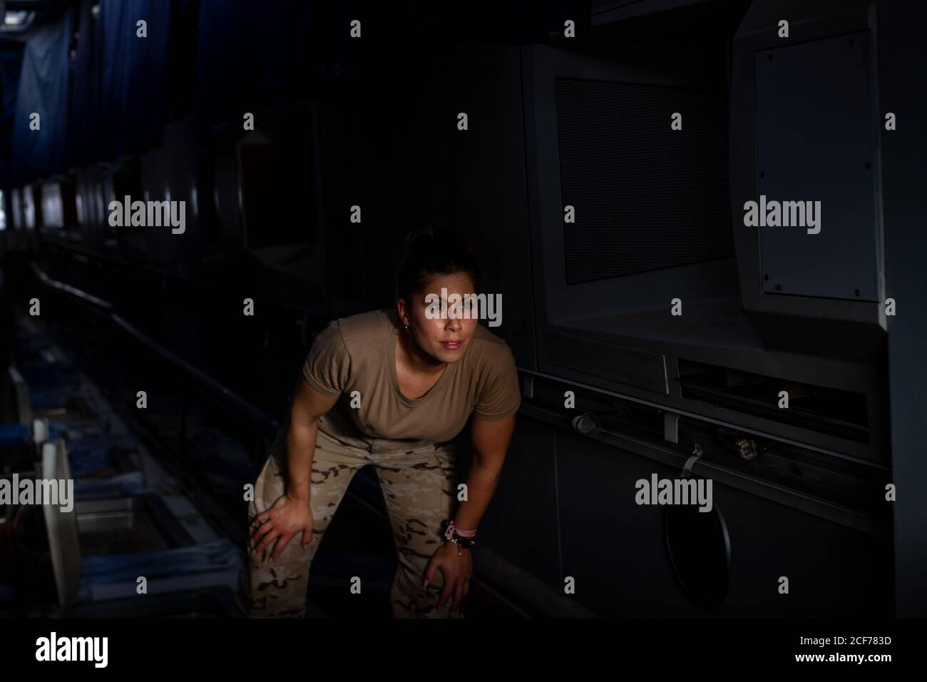 Side view of strong female soldier pointing up while looking at sky ...