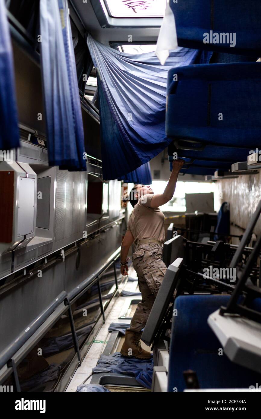 Attractive female soldier looking up while standing inside modern ...