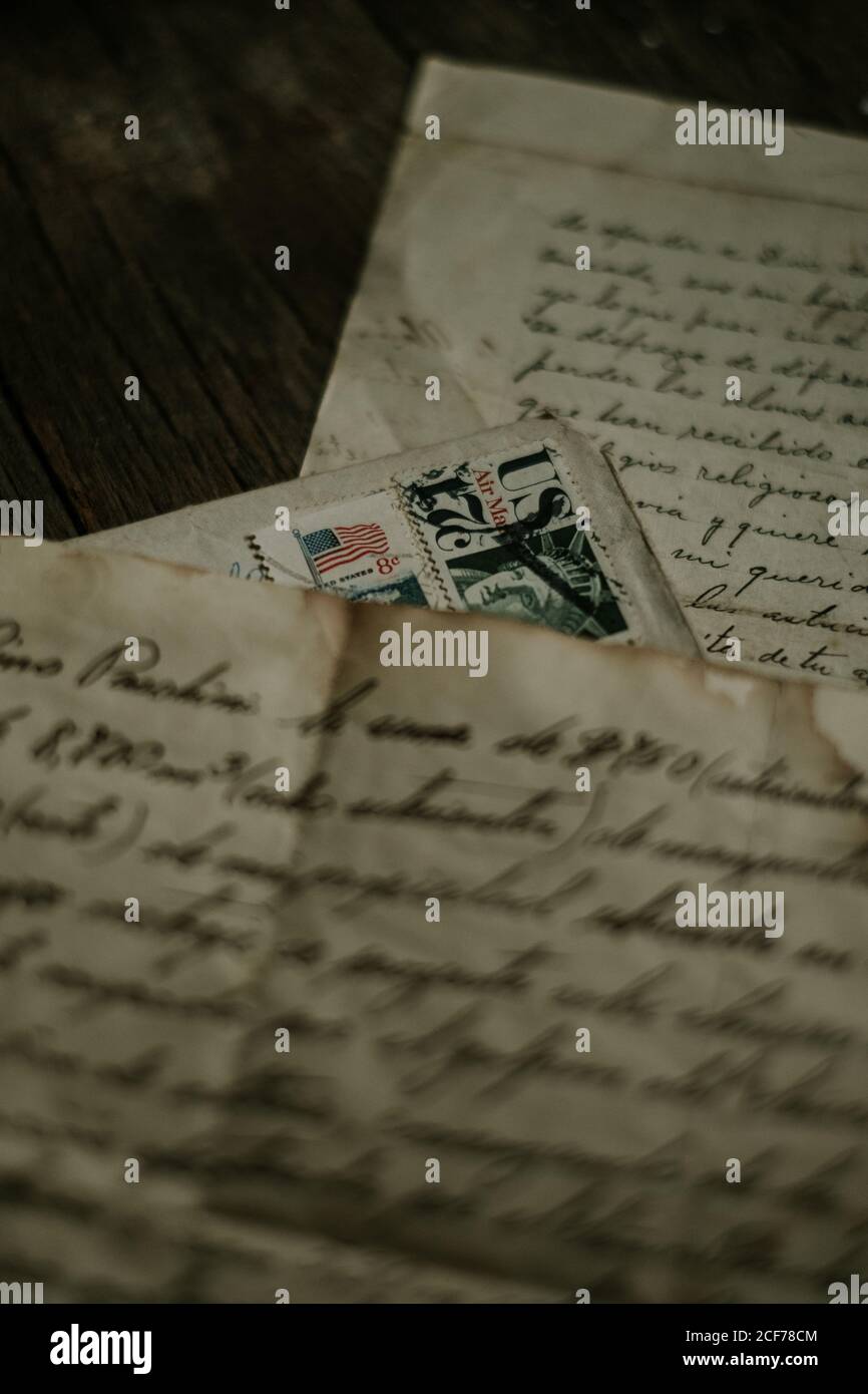 From above shabby aged letters and envelope with postage stamp placed ...