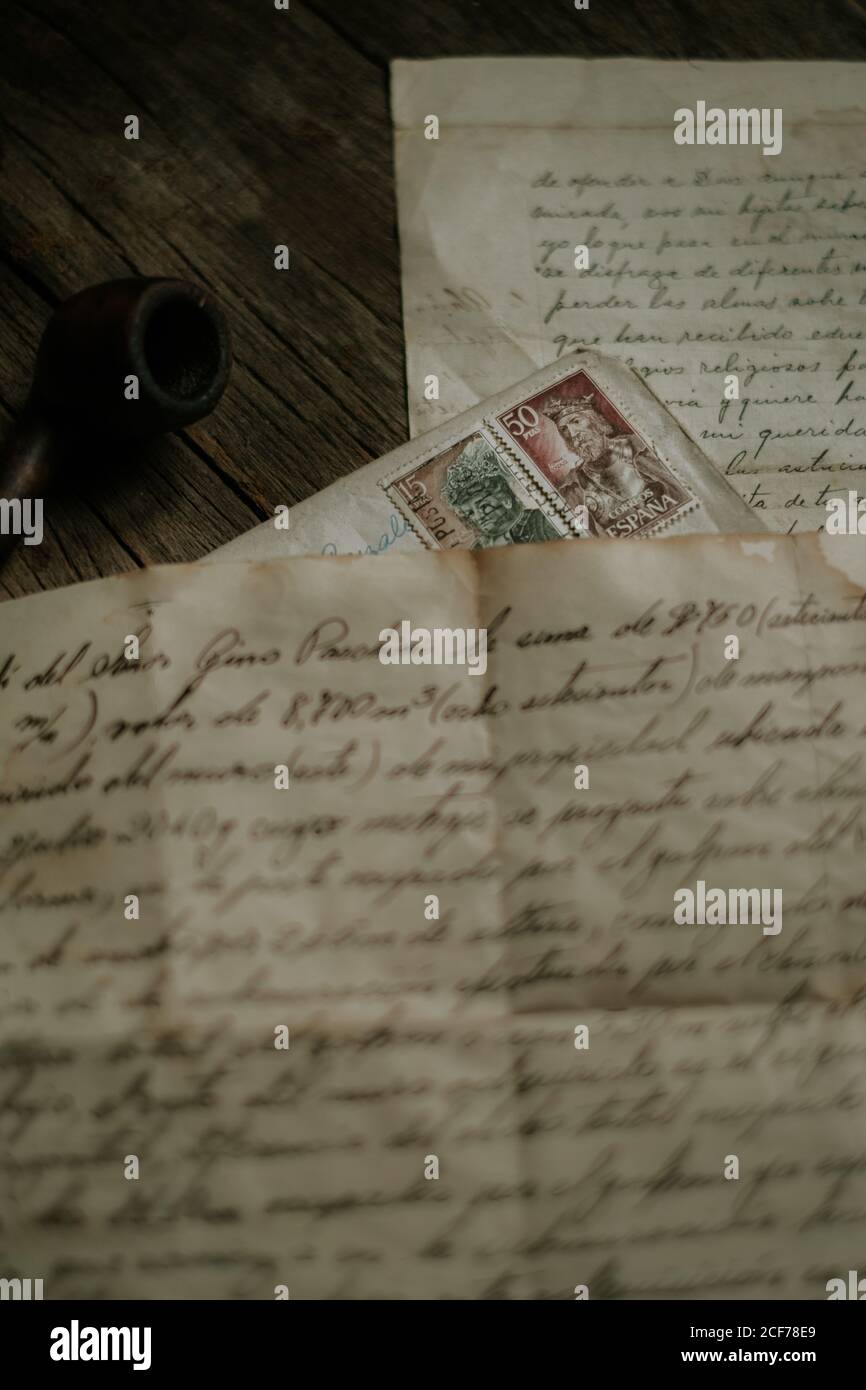 From above shabby aged letters and envelope with postage stamp placed ...