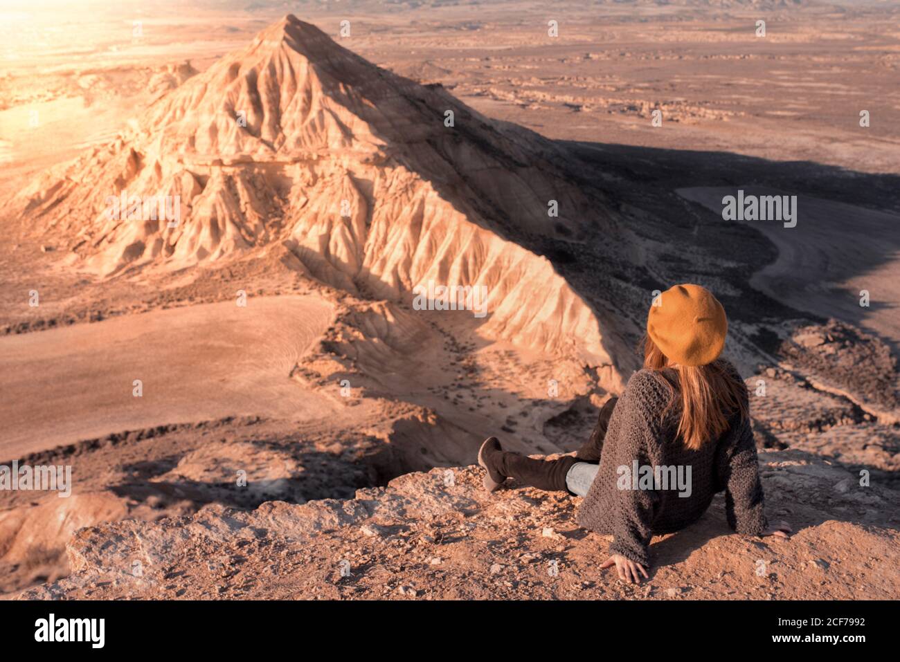 Stylish Woman sitting on cliff in badlands Stock Photo - Alamy