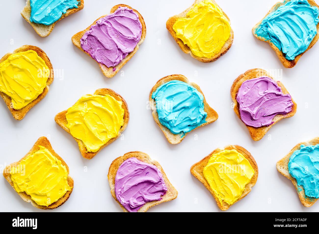 Funny toasted bread with colored cheese spread. Overhead view Stock ...
