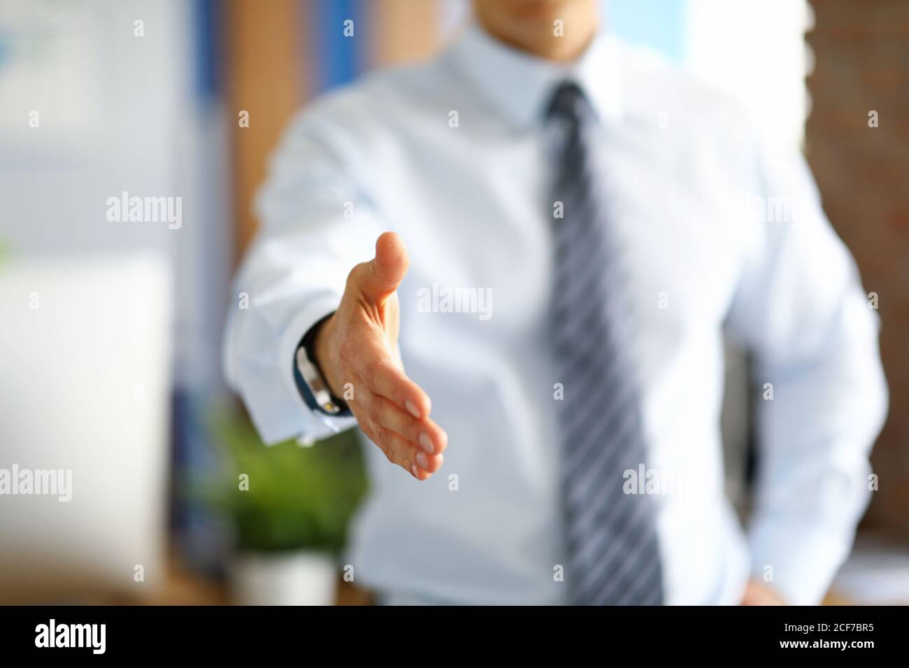 Businessman holds out his hand for a handshake Stock Photo - Alamy