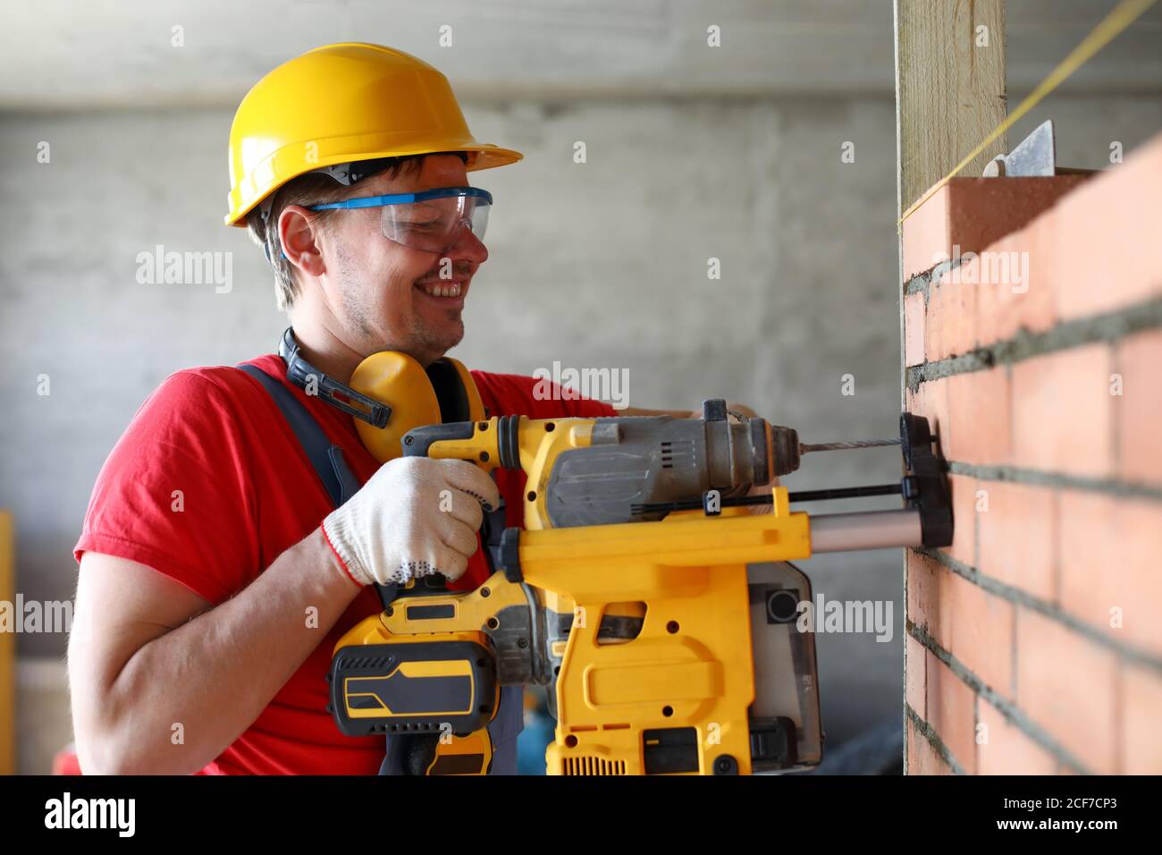 Builder drilling hole in wall, construction site Stock Photo - Alamy