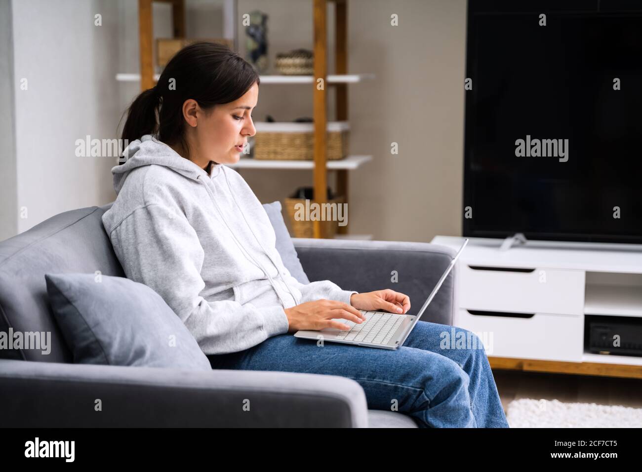 Women Using Computer Laptop On Couch Or Sofa Stock Photo - Alamy