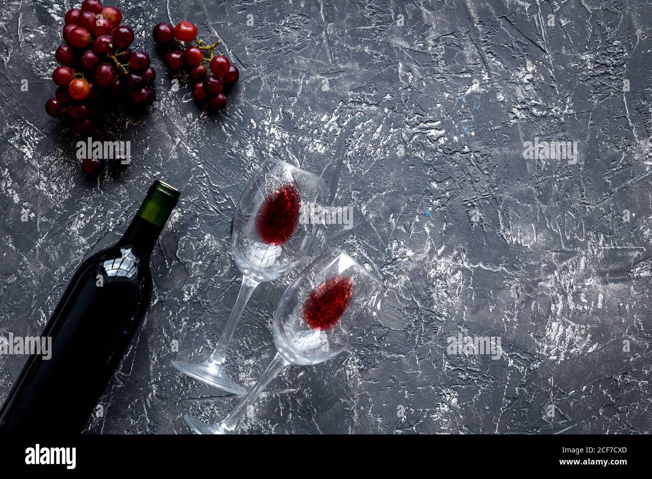 Red wine with grape - in glasses and bottle - on grey desk top view ...