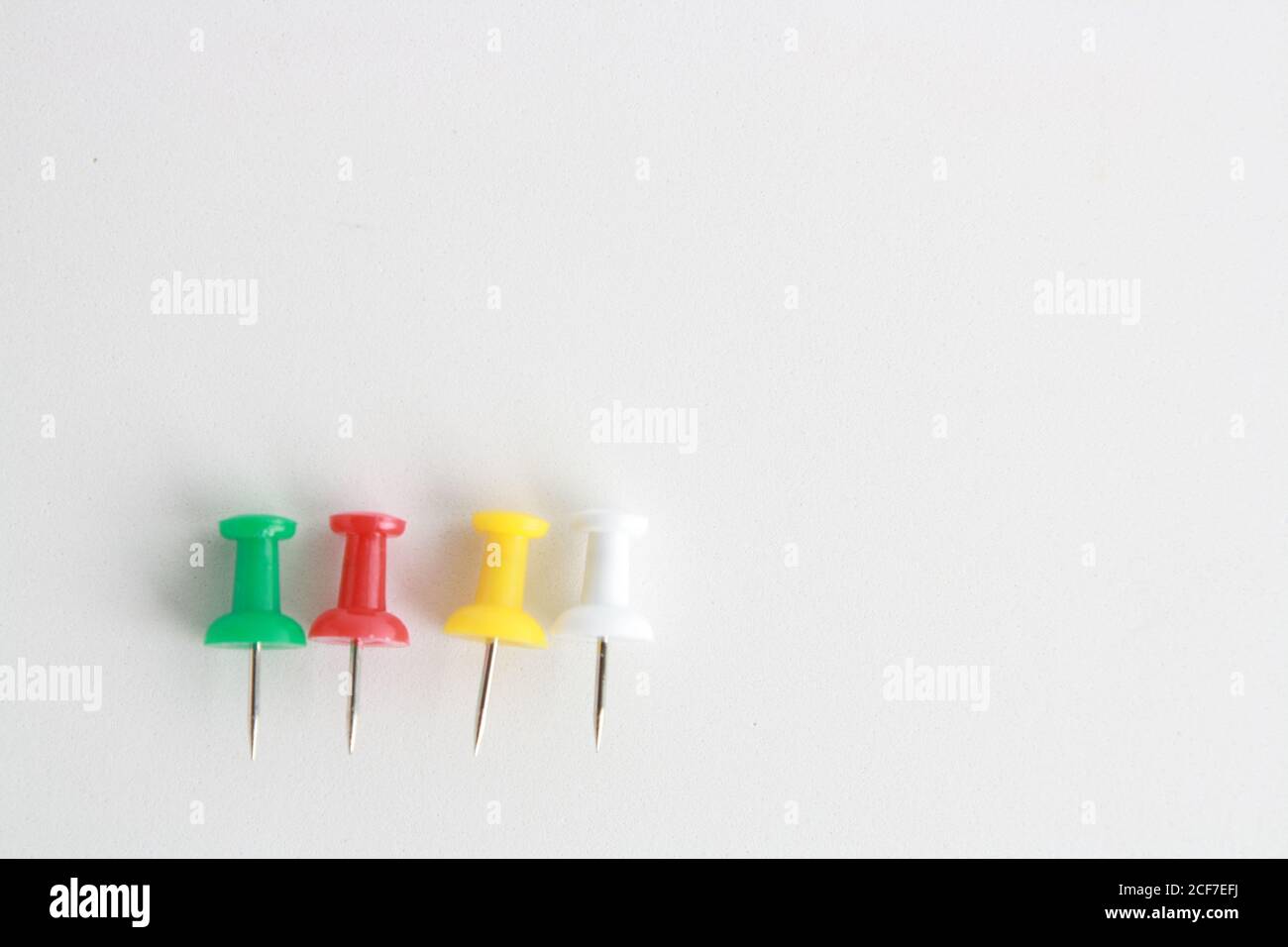 Top view of the colourful plastic thumb stacks on the white background ...
