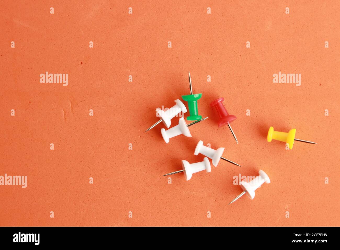 Top view of the colourful plastic thumb stacks on the orange background ...