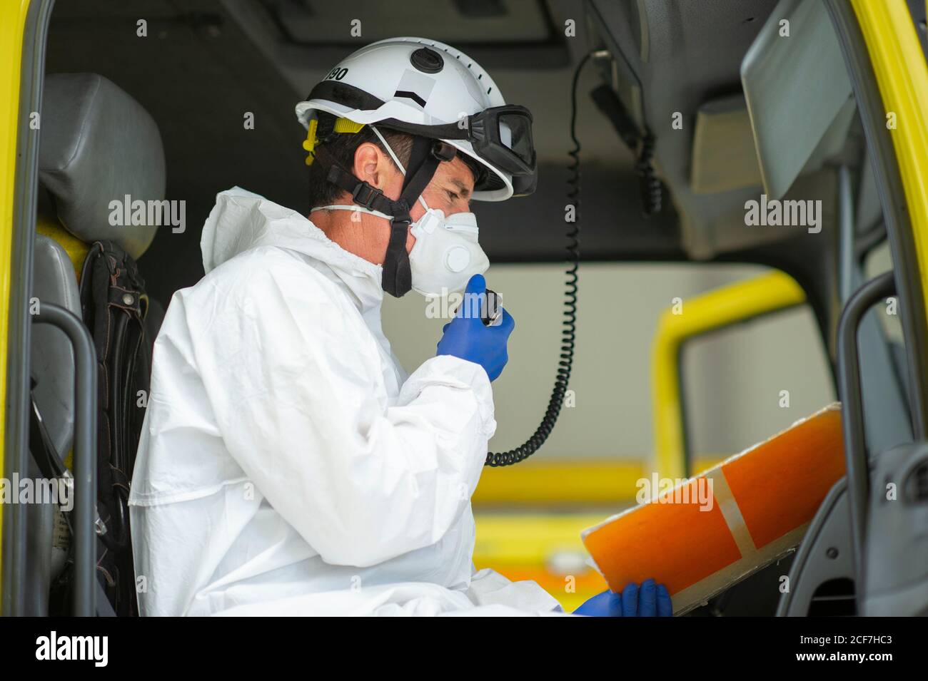 Side view of fireman wearing protective uniform and hard helmet with ...