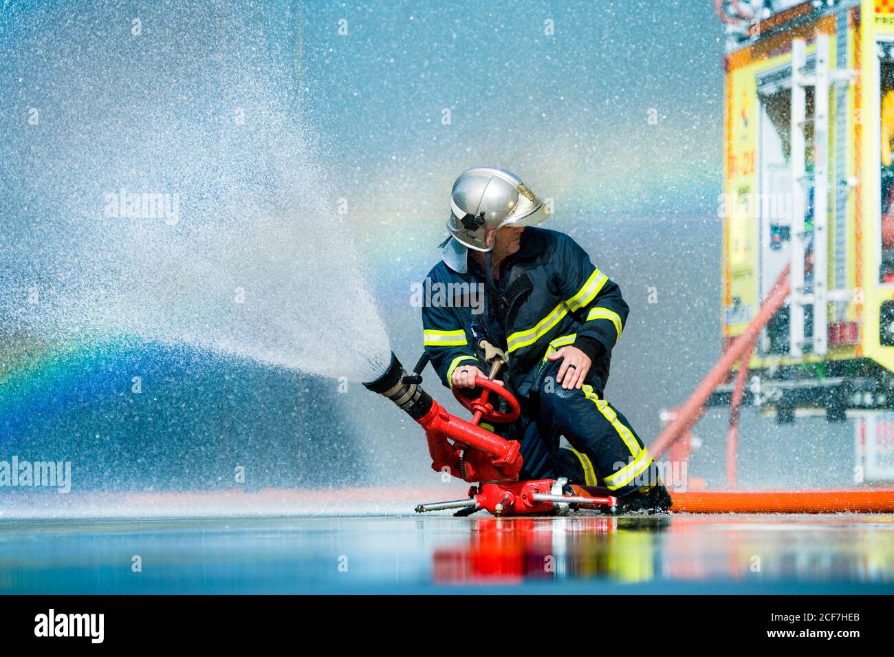 anonymous fireman fighting fire with water Stock Photo - Alamy