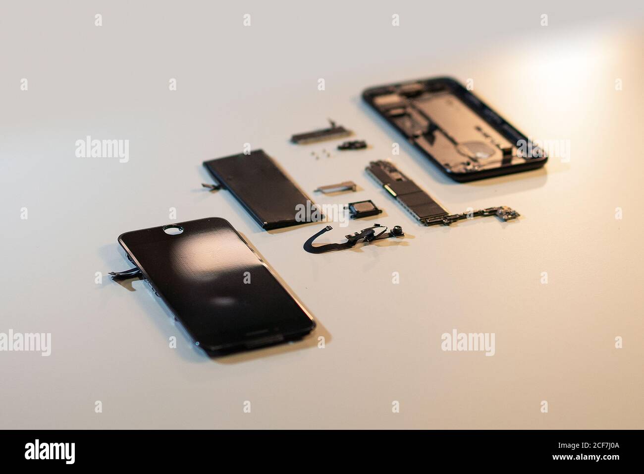 Details of damaged and disassembled mobile phone placed on white ...