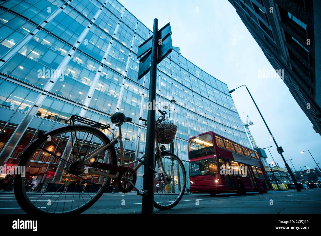 Cycle and bus on road near new modern building with glass facade and ...