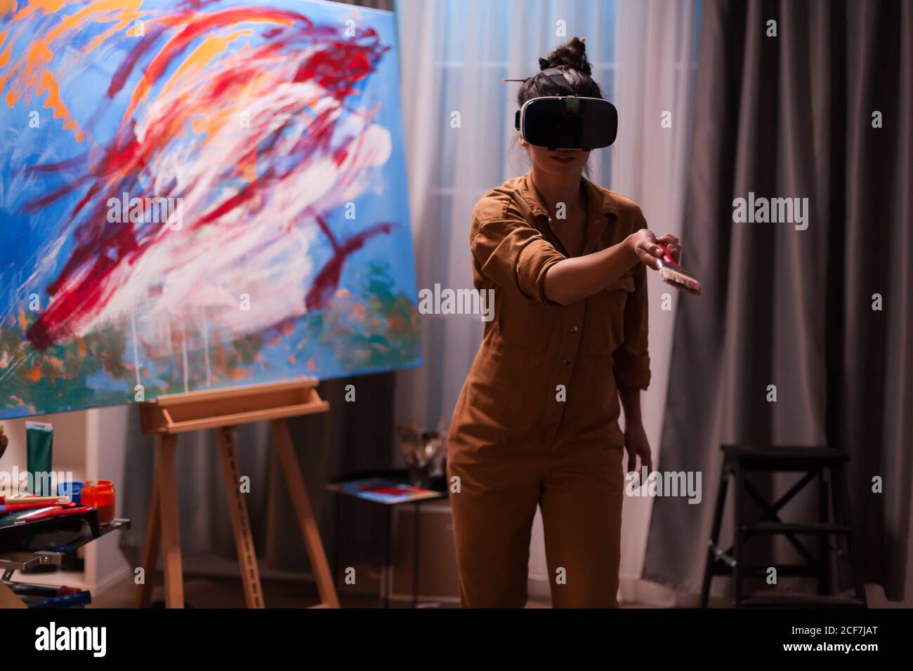 Painter wearing virtual reality headset in art studio. Modern artwork ...