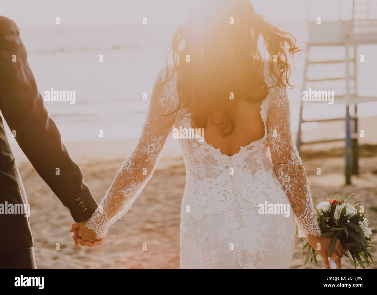Back view of crop groom in classy suit and elegant bride in wedding ...