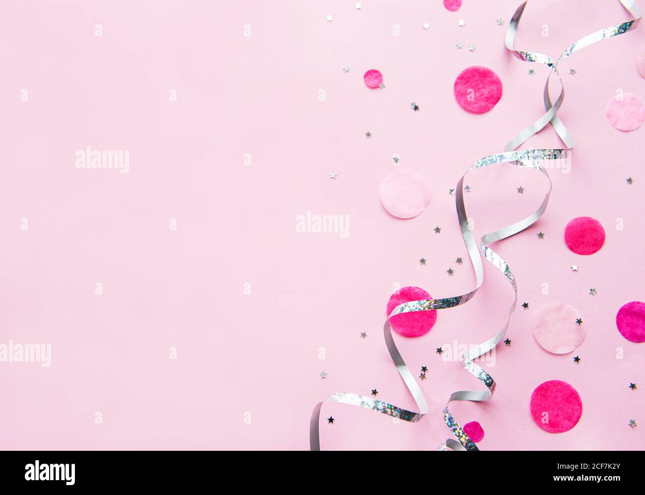 Festive minimal flat lay style composition with silver ribbons and pink ...