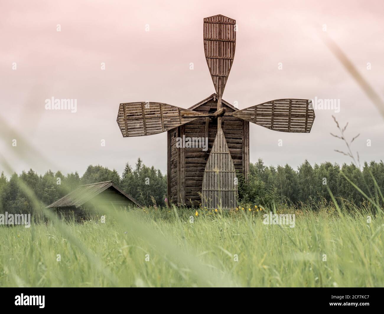 Engaging old wooden windmill on border of field and forest in Finland ...