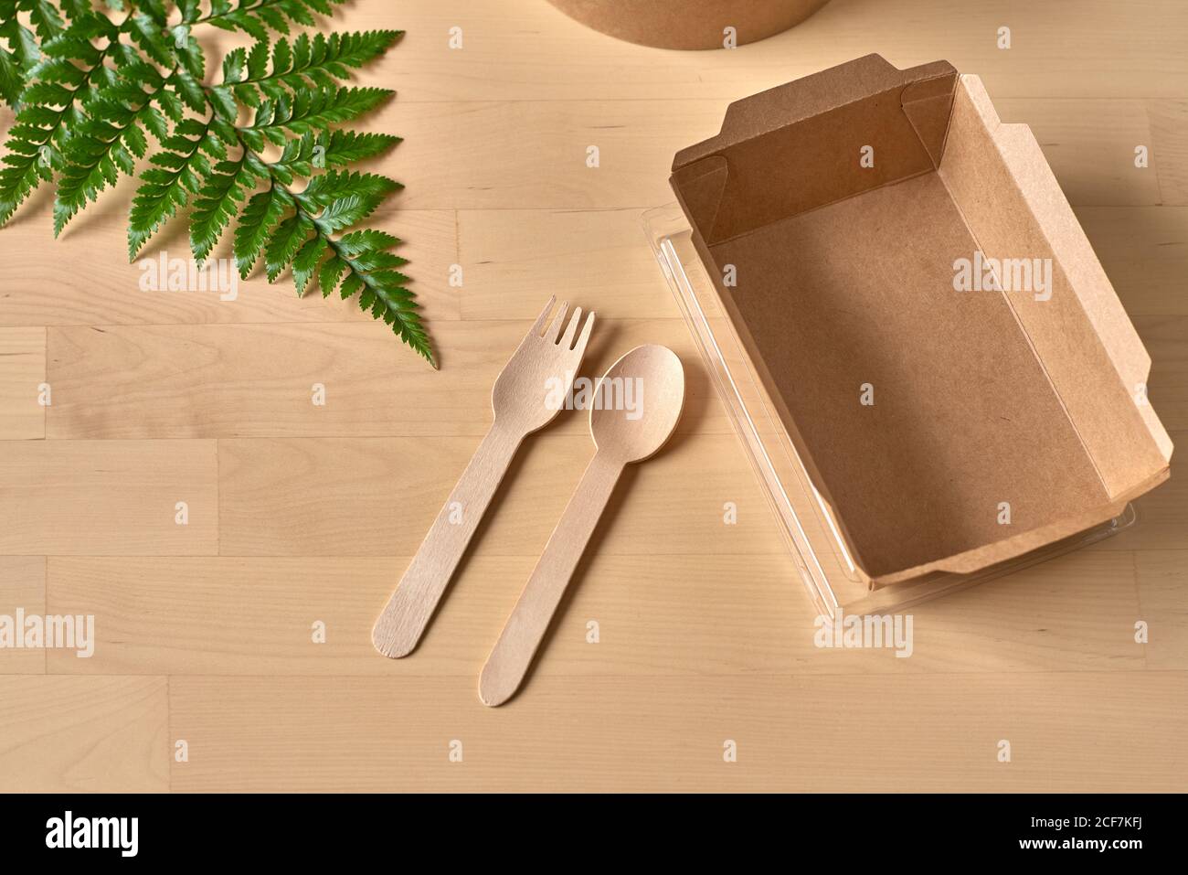 Top view of recyclable carton food package and wooden fork and knife ...