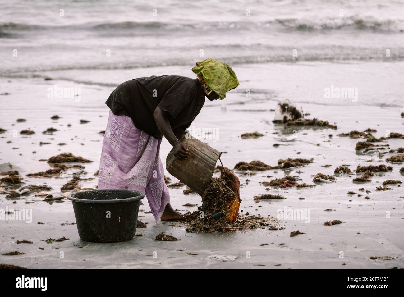Gambia, Africa - August 6, 2019: Side view of black female pouring ...