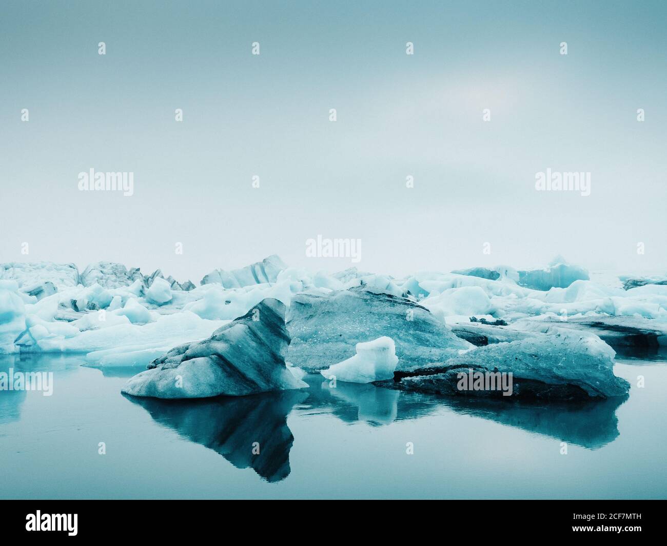 Picturesque view of ice on water surface between snow in winter in ...