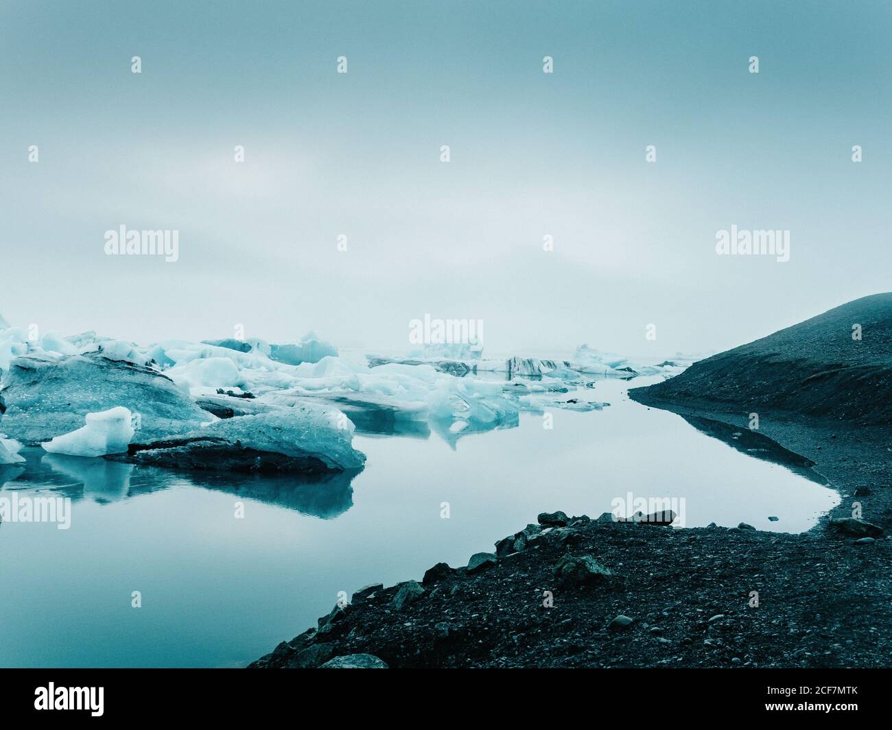 Picturesque view of ice on water surface between snow in winter in ...
